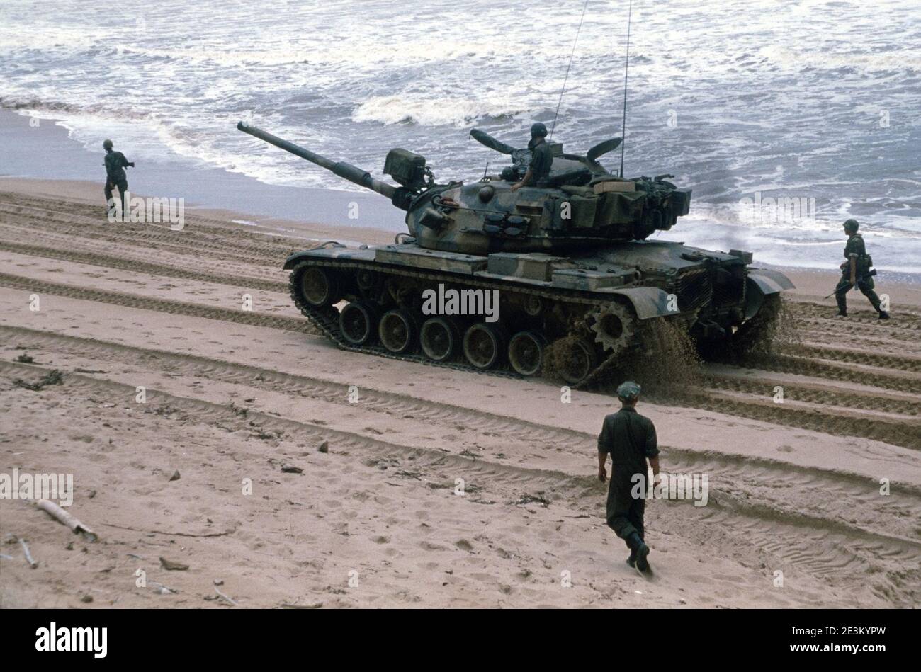 Marines of the 31st Marine Amphibious Unit patrol along a beach with an ...