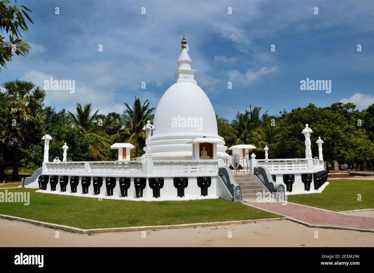 Buddhist stupa with Buddha statue at the Dambakola Patuna Sangamitta ...