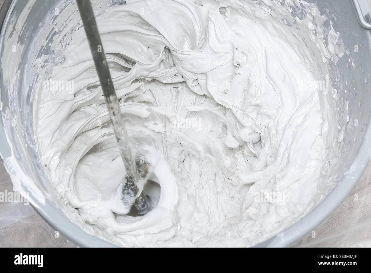 A male worker spreads the putty mixture and flattens the wall Stock ...