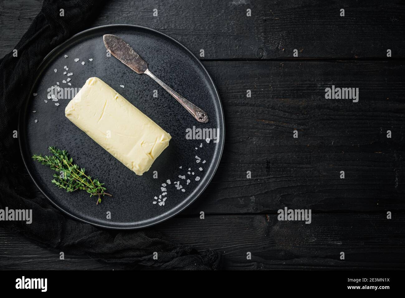 Butter or spread brick, on black wooden table background, top view flat ...