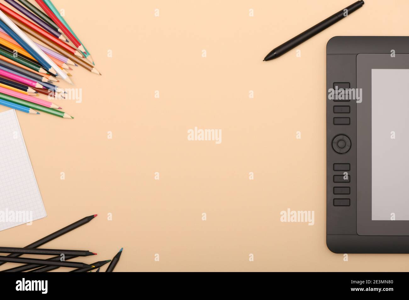 Graphic monitor stylus on peachy color table. Black tablet computer ...