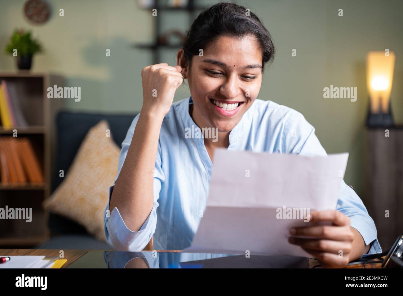 Young business woman reading paper letter feeling overjoyed and ...