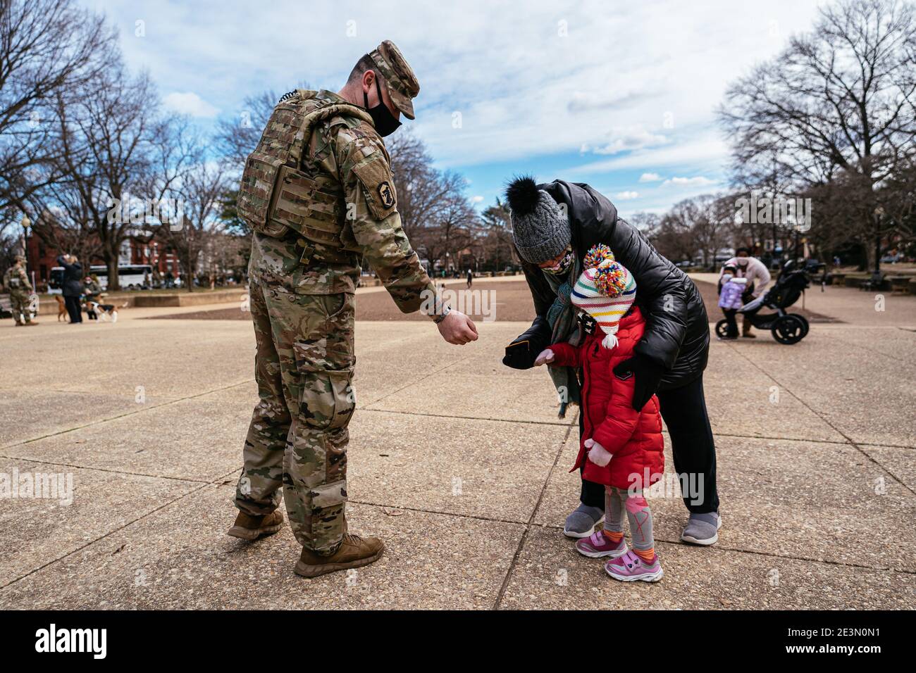 A National Guard soldier gives a child an American flag patch off their ...