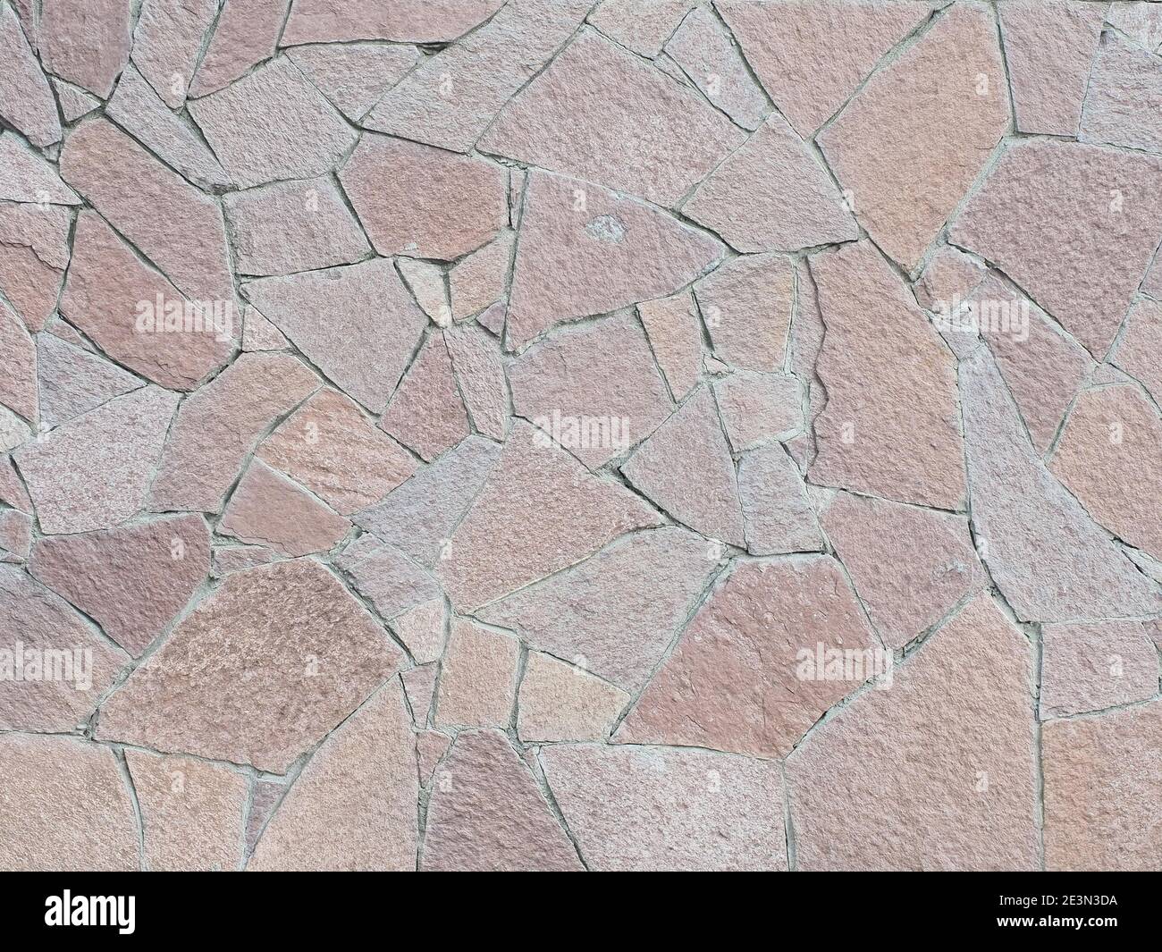 A wall with decorative cladding lined with granite pieces of tiles of ...