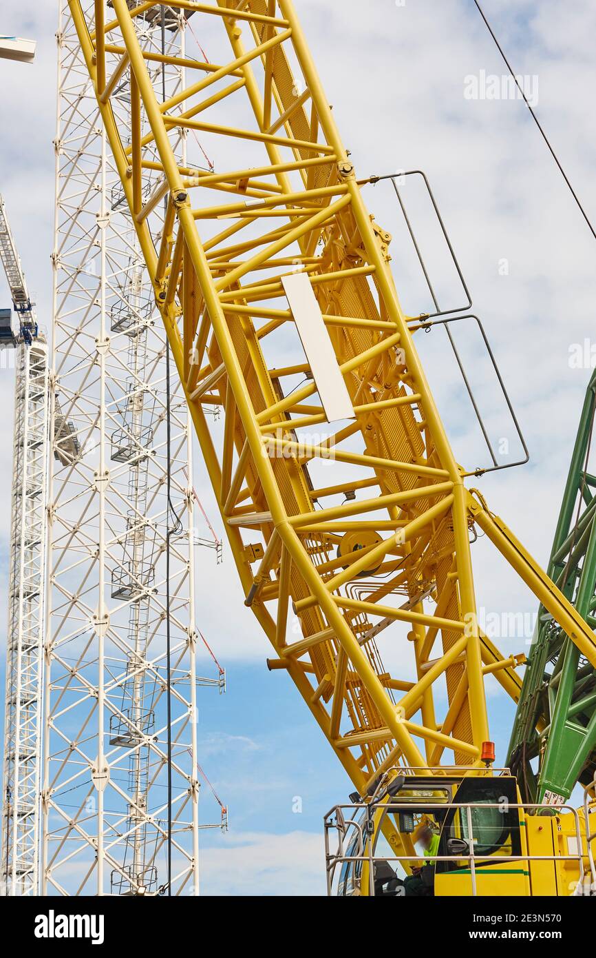 Telescopic cranes under a blue sky. Construction engineering industry ...