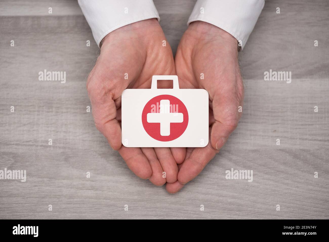 Hands holding a paper medical briefcase; Symbol of health insurance ...