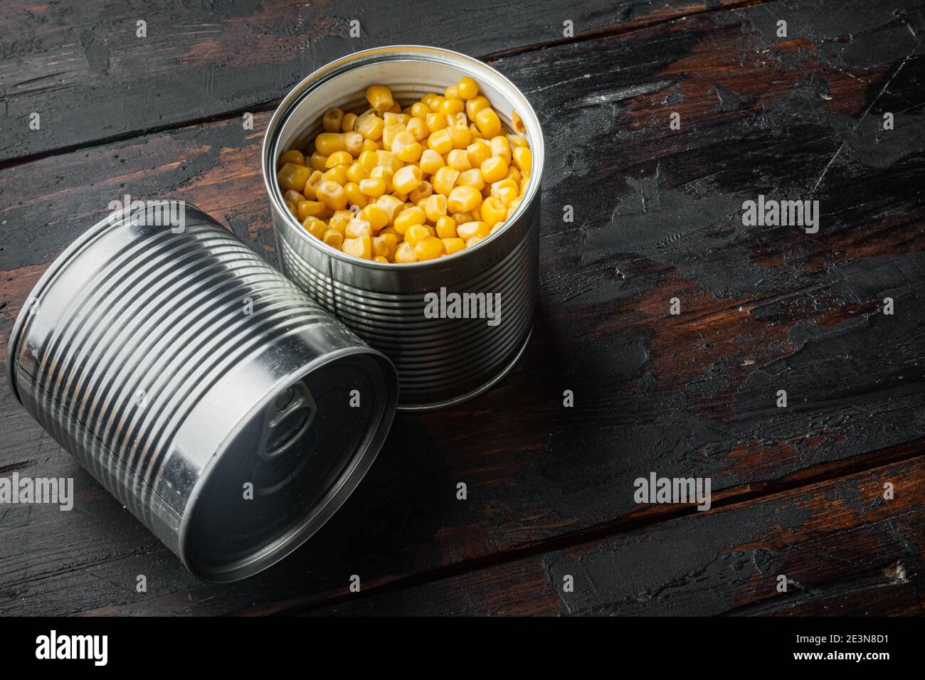 Canned corn in can, on old dark wooden table background with copy space ...