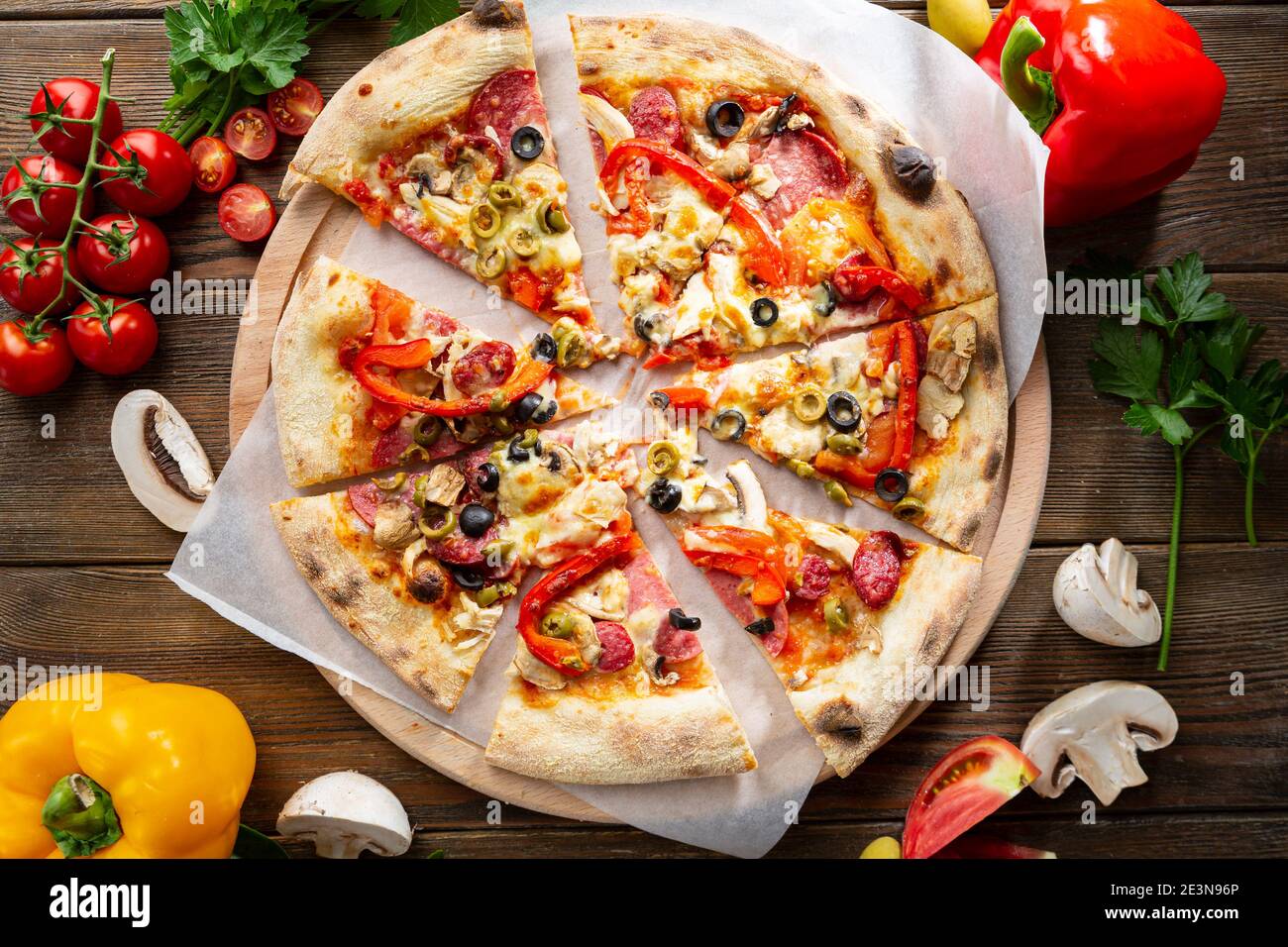 Overhead view of sliced pizza on cutting board, pizza ingredients Stock ...