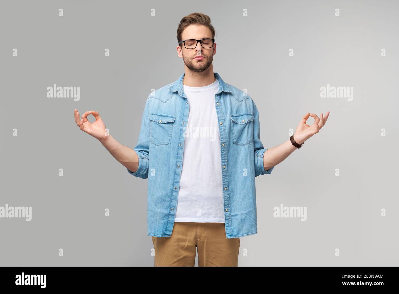 Concentrated bearded man meditating and relaxing trying to calm down ...