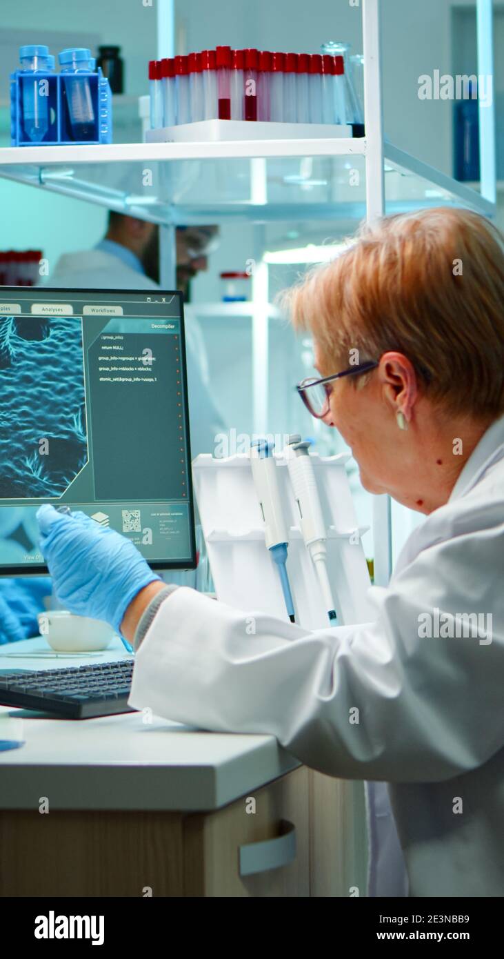 Medical research scientist typing codes on pc in biological applied ...