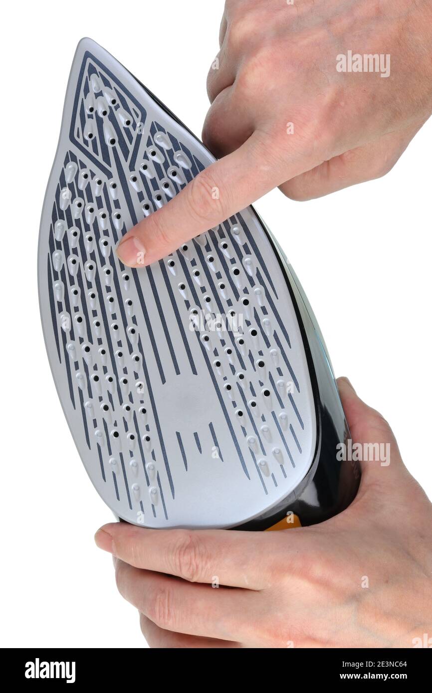 A man holds an iron and checks the temperature with his finger ...