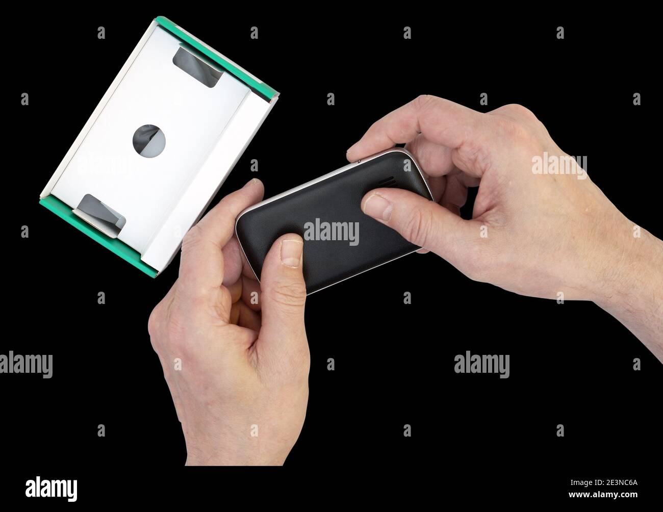 Old man unpacks new mass production mobile phone. Isolated on black ...
