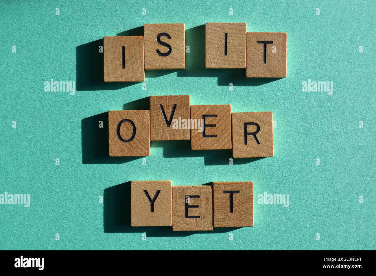 Is It Over Yet, phrase in wooden alphabet letters isolated on turquoise ...