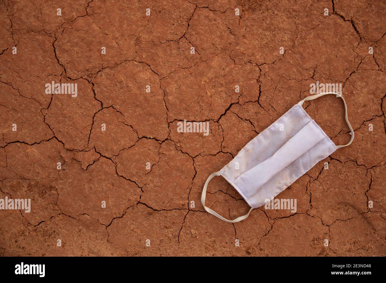 Waste during COVID-19. Discarded on cracked ground. Trash on dry soil ...