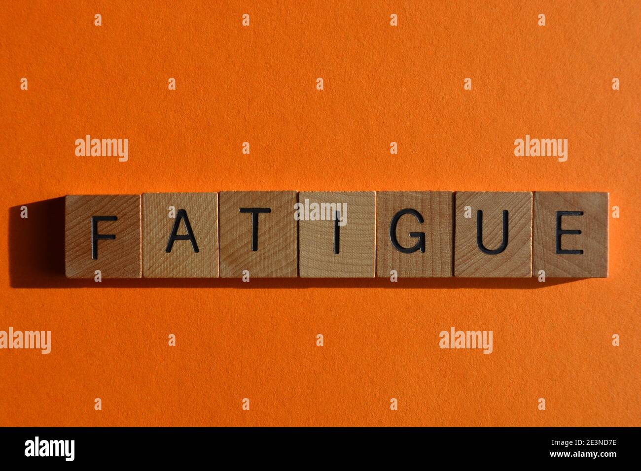 Fatigue, word in wooden alphabet letters isolated on bright orange ...