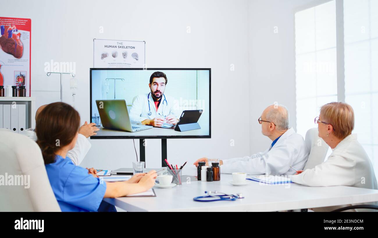 Medical team holding online conference in boardroom with man specialist ...