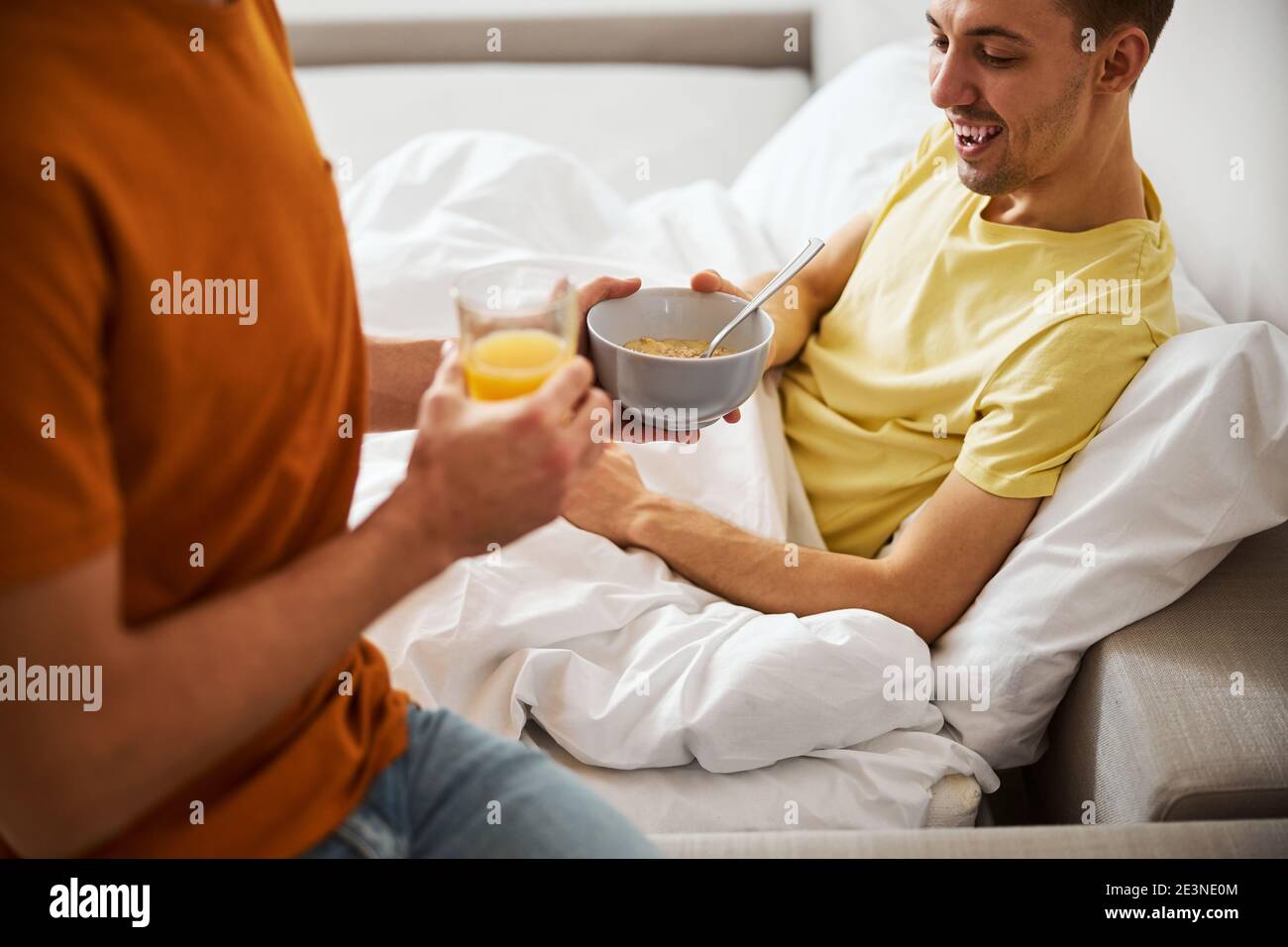 Loving and caring man serving boyfriend breakfast in bed Stock Photo ...