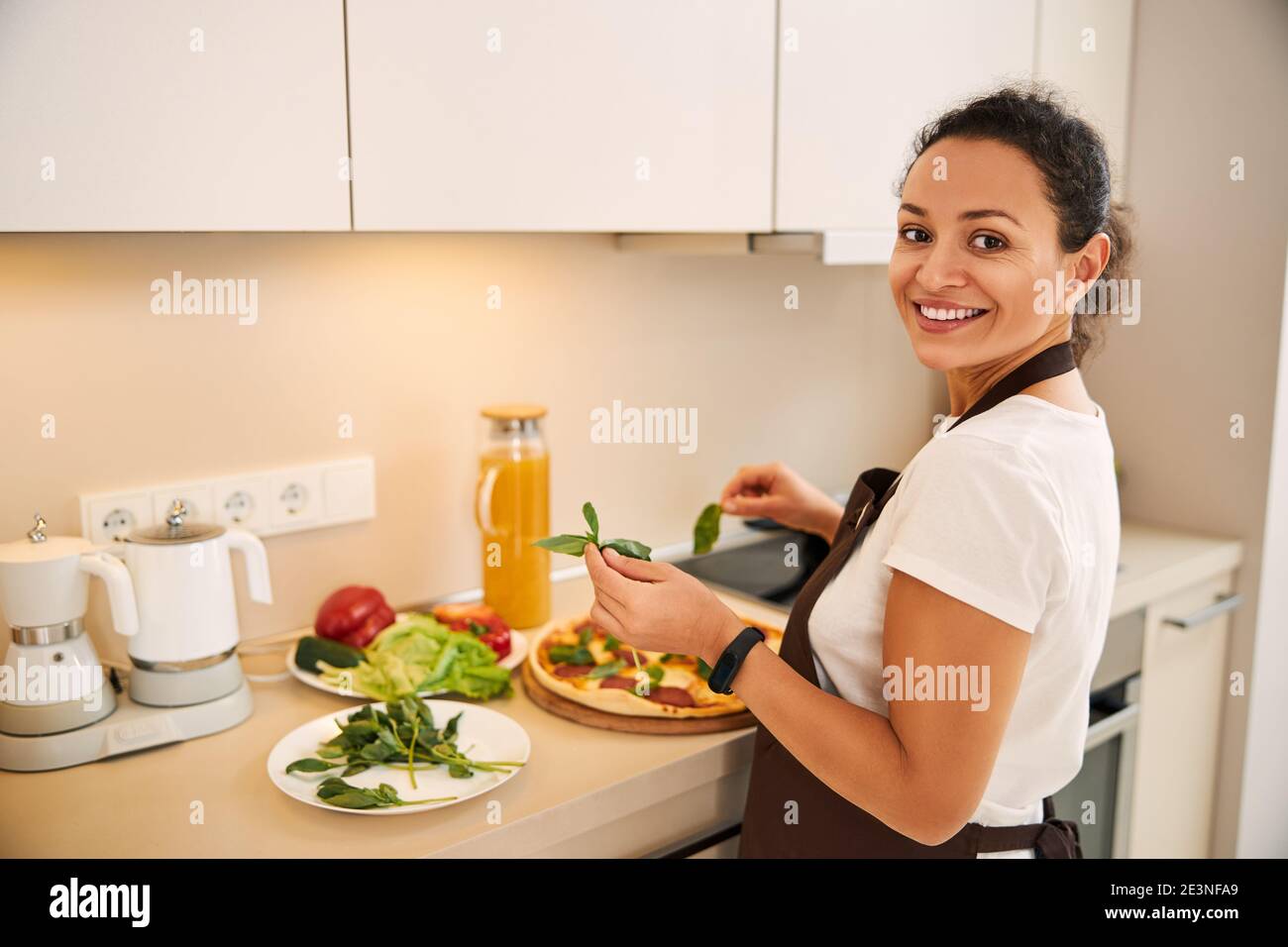 Contented lady following the recipe and smiling while cooking Stock ...