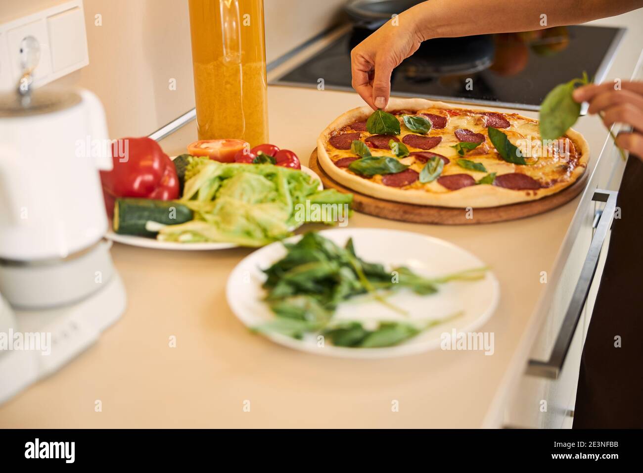 Final touch in making pizza at home before serving it Stock Photo - Alamy