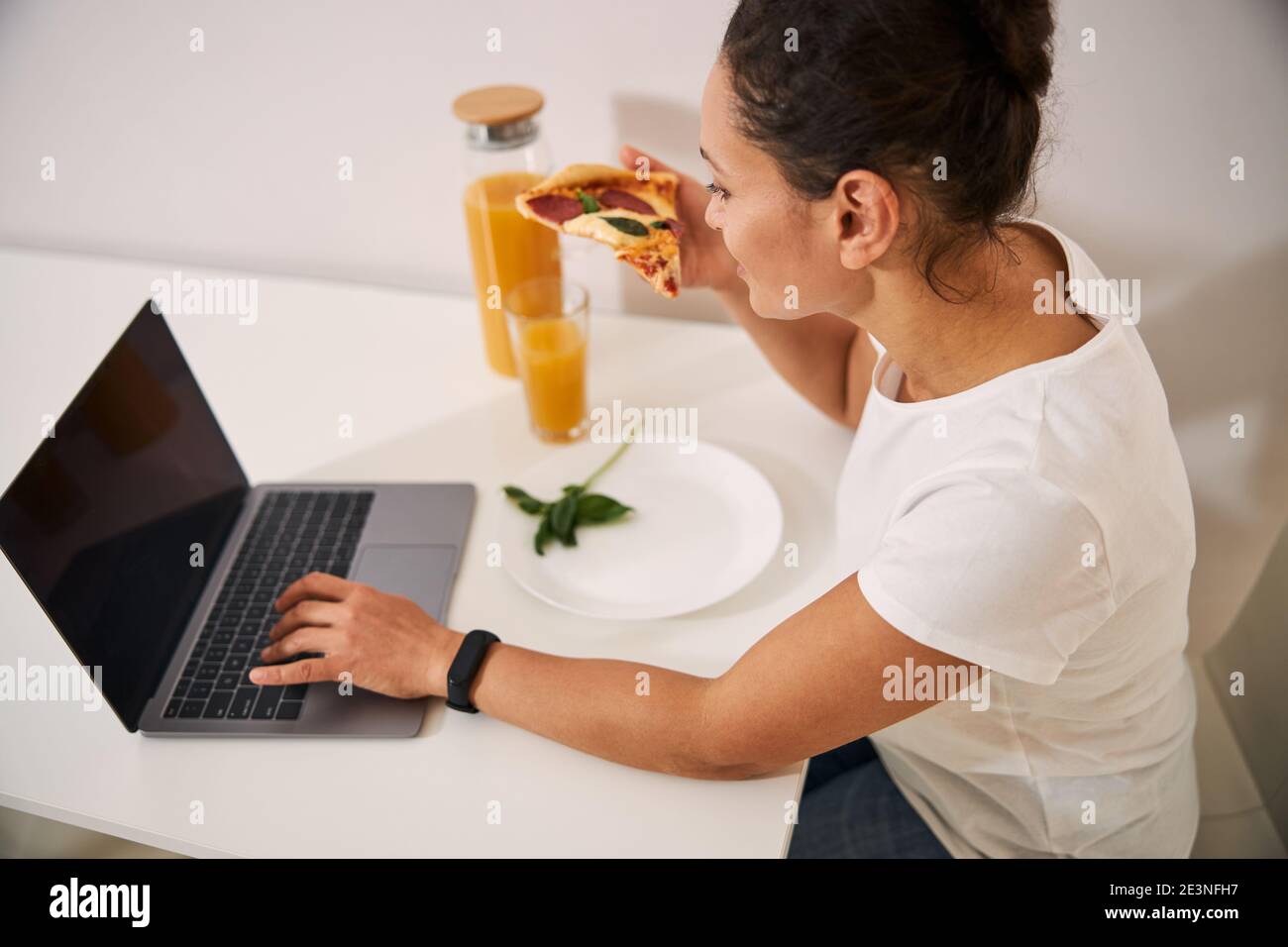 Relaxed lady eating at home and chatting online Stock Photo - Alamy