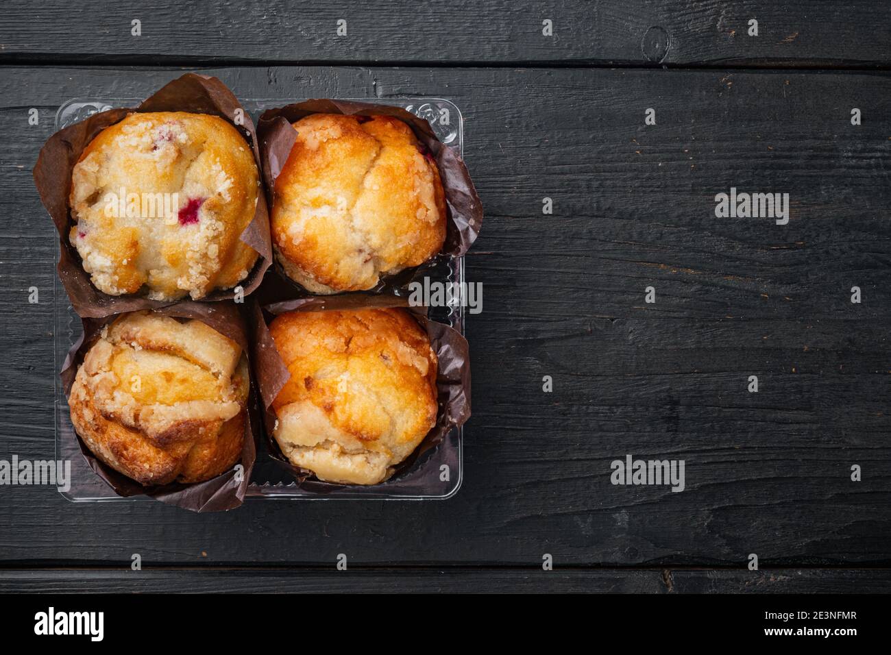 Muffins in plastic container, on black wooden table background, top ...