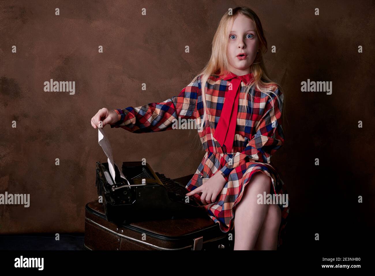 little girl is typing text on typewriter. retro style Stock Photo - Alamy