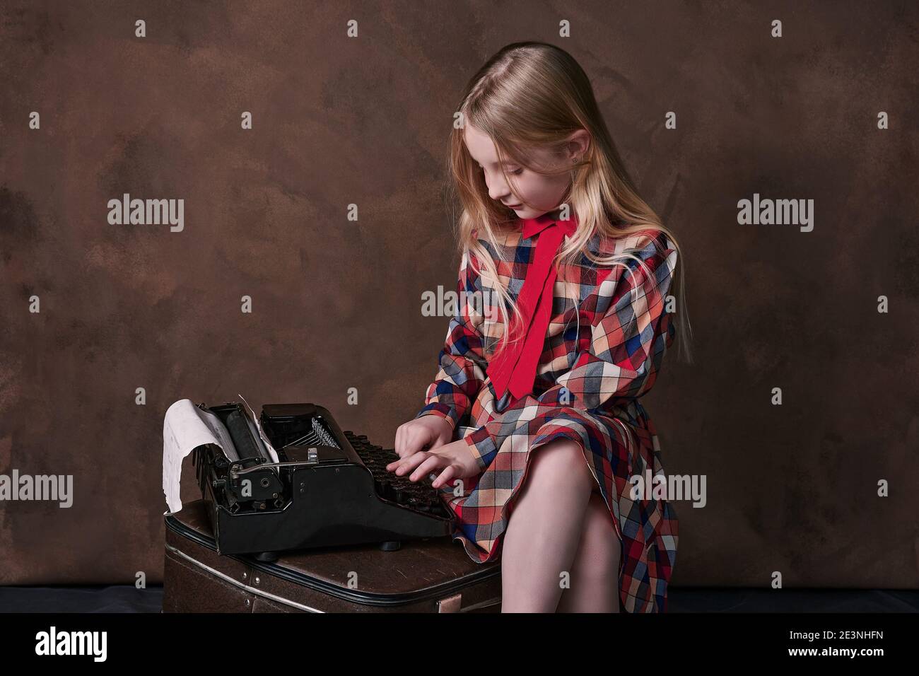 little girl is typing text on typewriter. retro style Stock Photo - Alamy