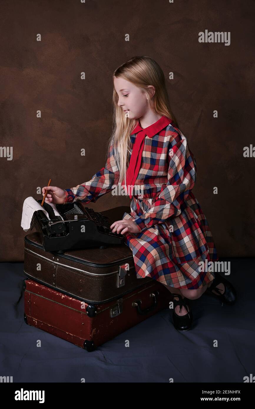 little girl is typing text on typewriter. retro style Stock Photo - Alamy