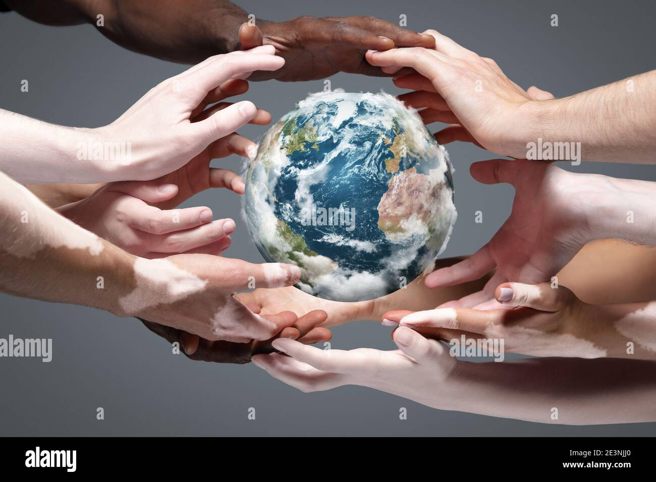 Hands holding, touching planet Earth, close up on grey background ...