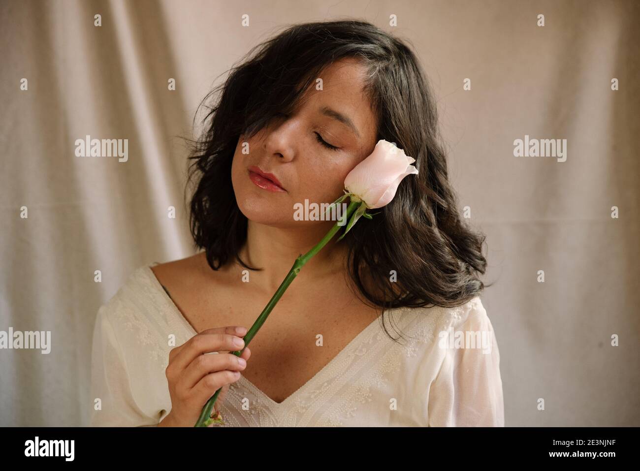 elegant woman portrait with pink rose and white delicate dress and ...