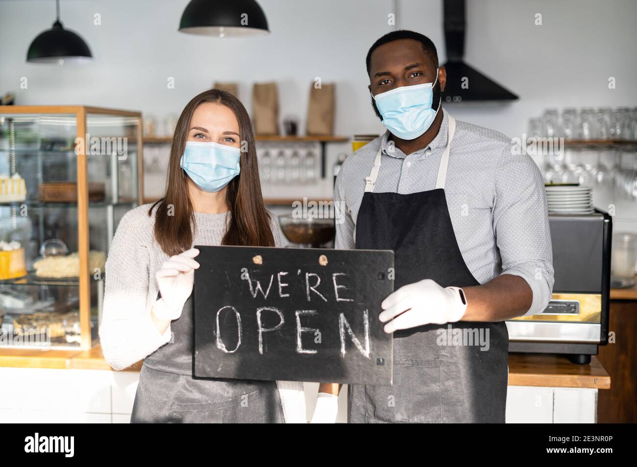 A waitress and a waiter in a medical masks Stock Photo - Alamy