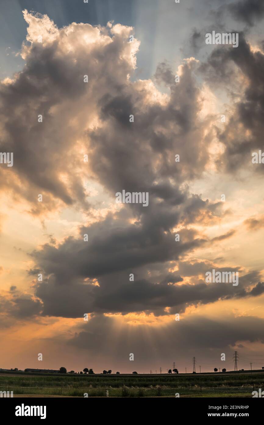 sun rays from a dark cloud during sunset Stock Photo - Alamy