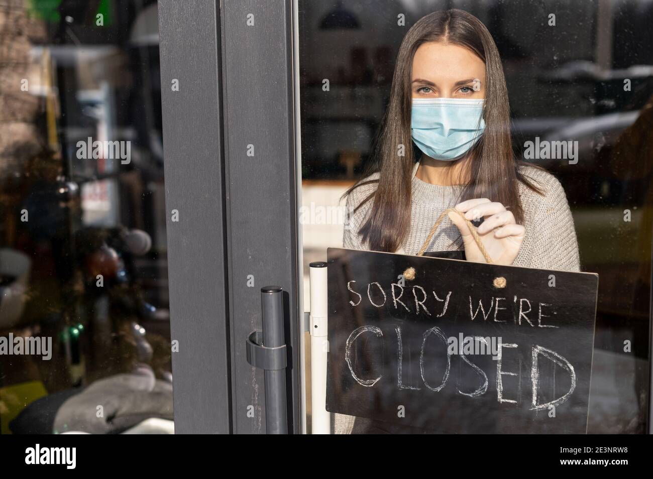 A waitress in a medical mask with closed sign Stock Photo - Alamy