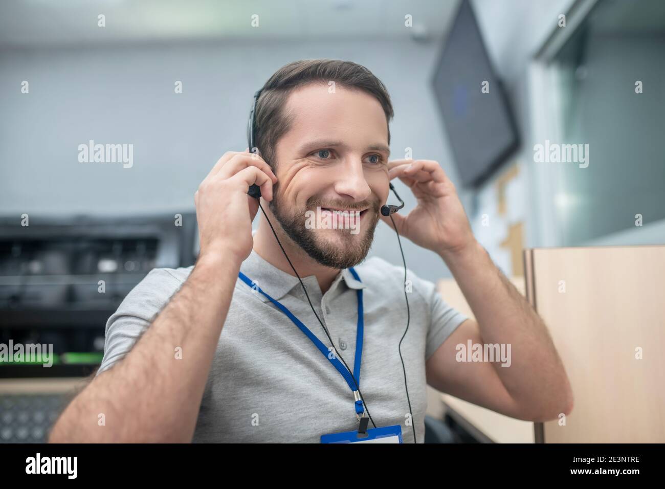 Man putting on headphones while sitting at workplace Stock Photo - Alamy