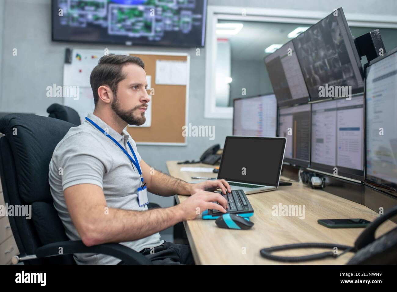 Man looking at computer screens sitting at keyboard Stock Photo - Alamy