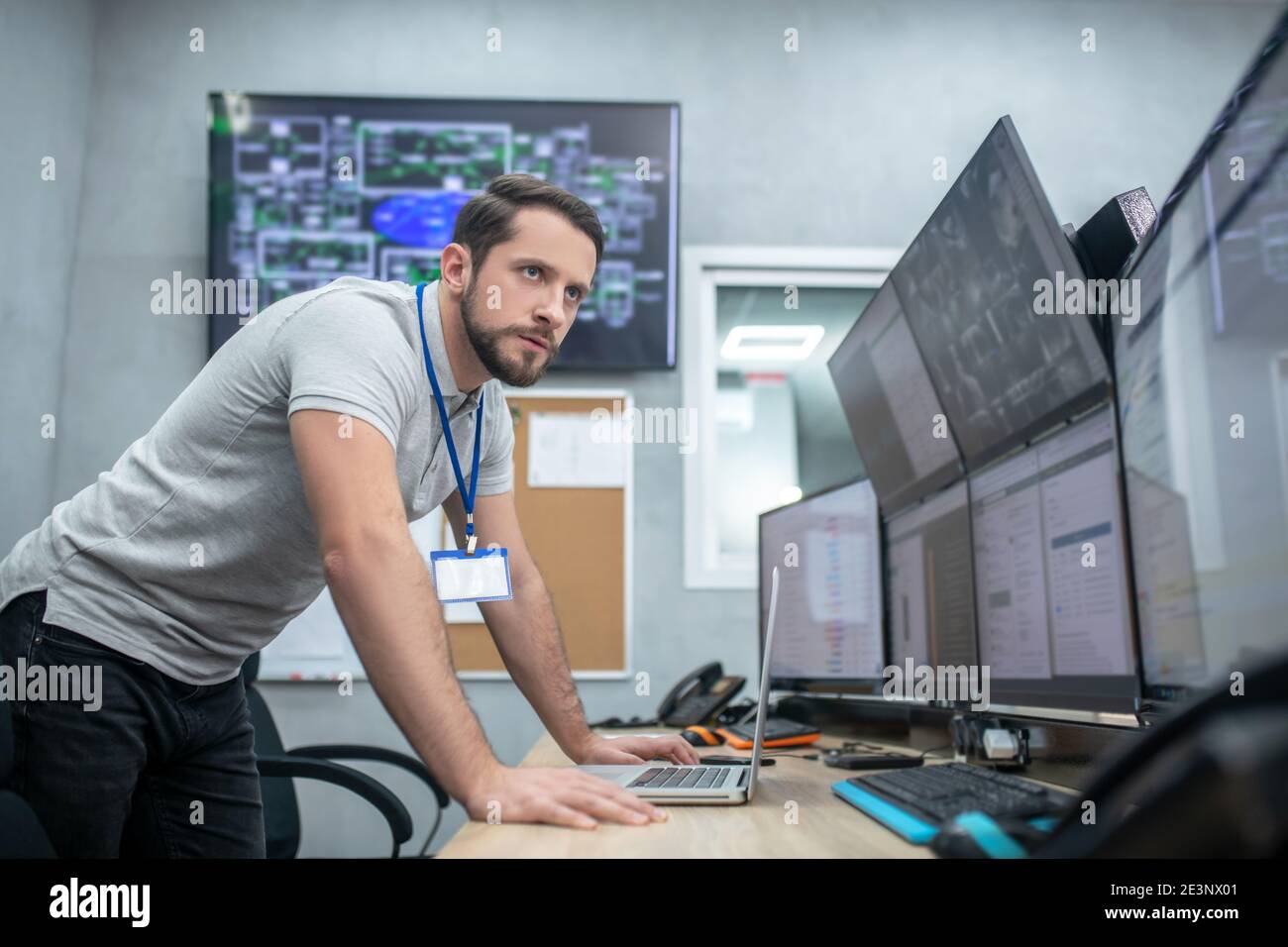 Serious man watching monitors at work Stock Photo - Alamy