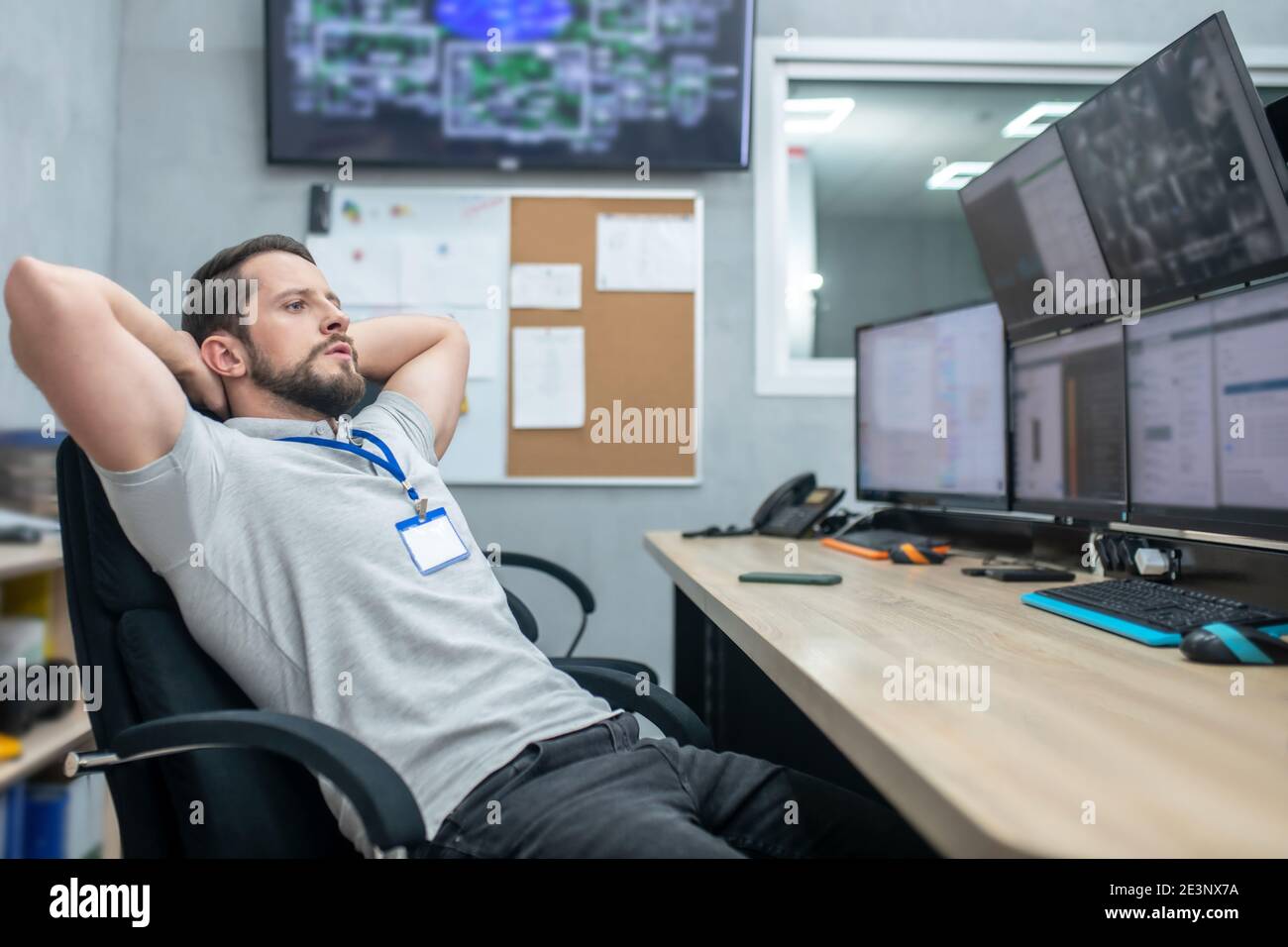 Tired man looking at monitors at work Stock Photo - Alamy
