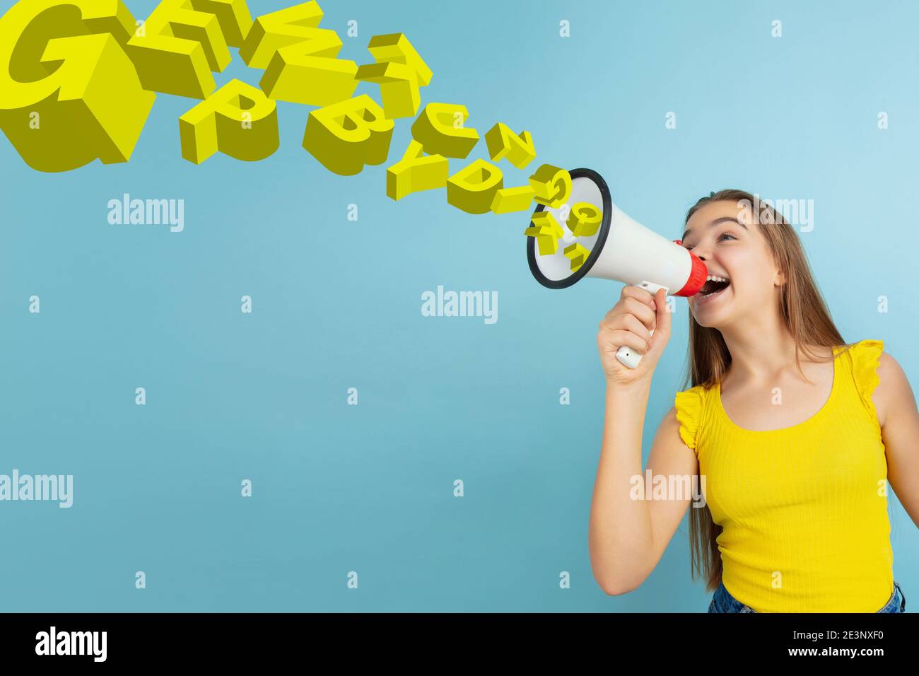 Caucasian girl shouting with megaphone, loudspeaker on blue studio ...