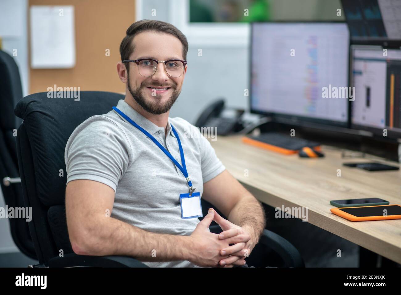 Confident man in glasses at an equipped workplace Stock Photo - Alamy