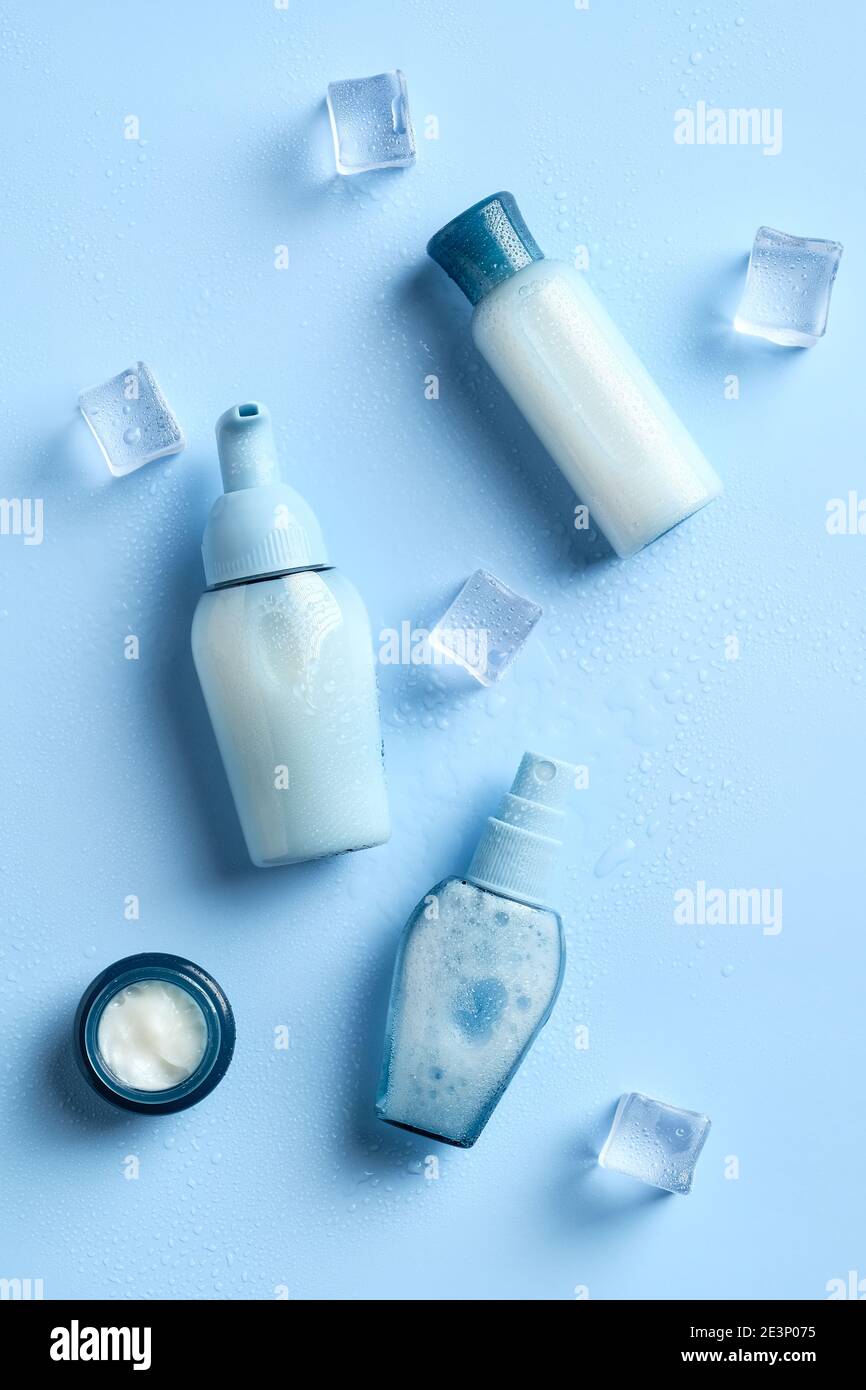 Hydration cosmetics set ob blue background. Transparent bottles and ice ...