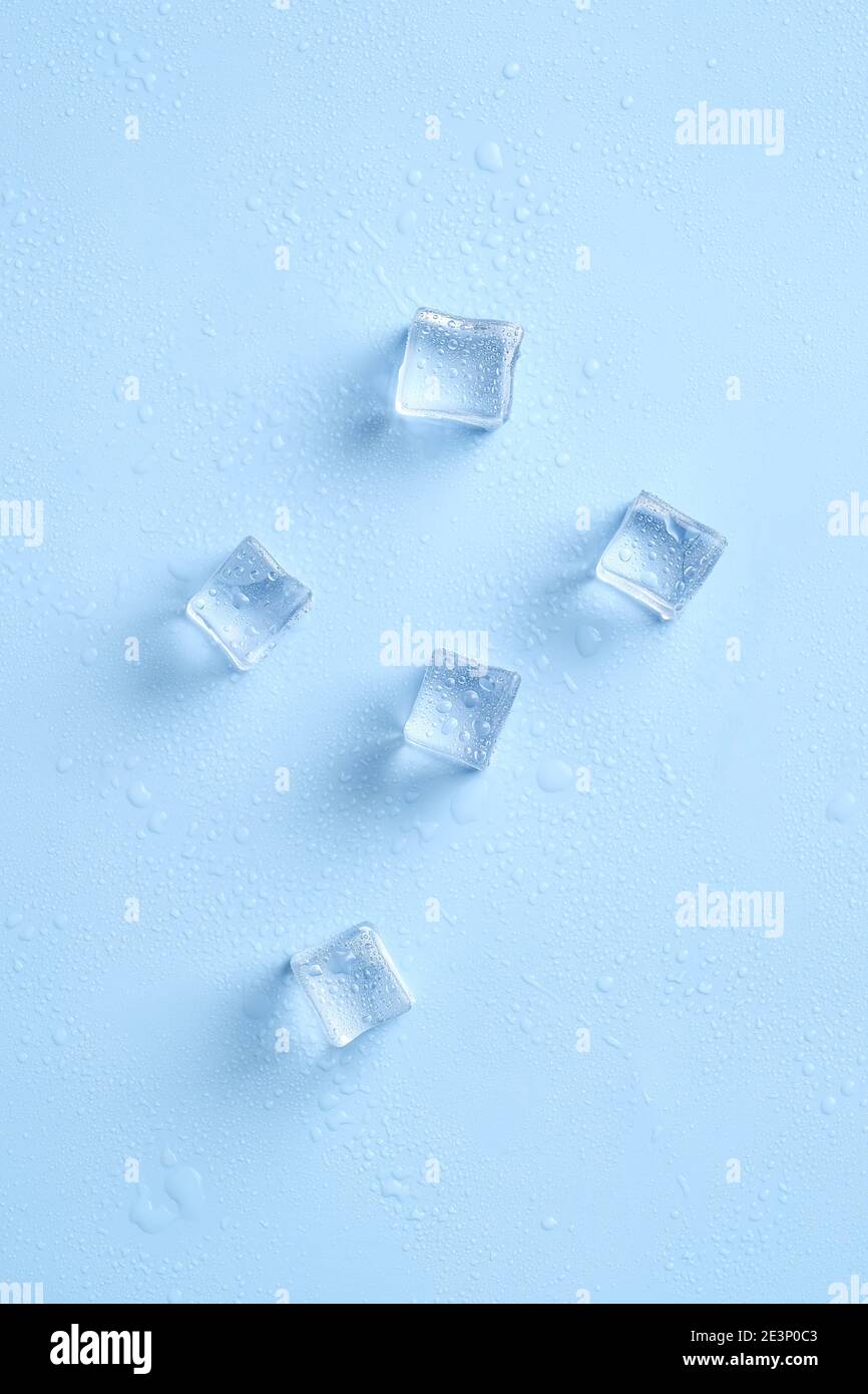 Shiny ice cubes and water drops on blue background. Top view Stock ...