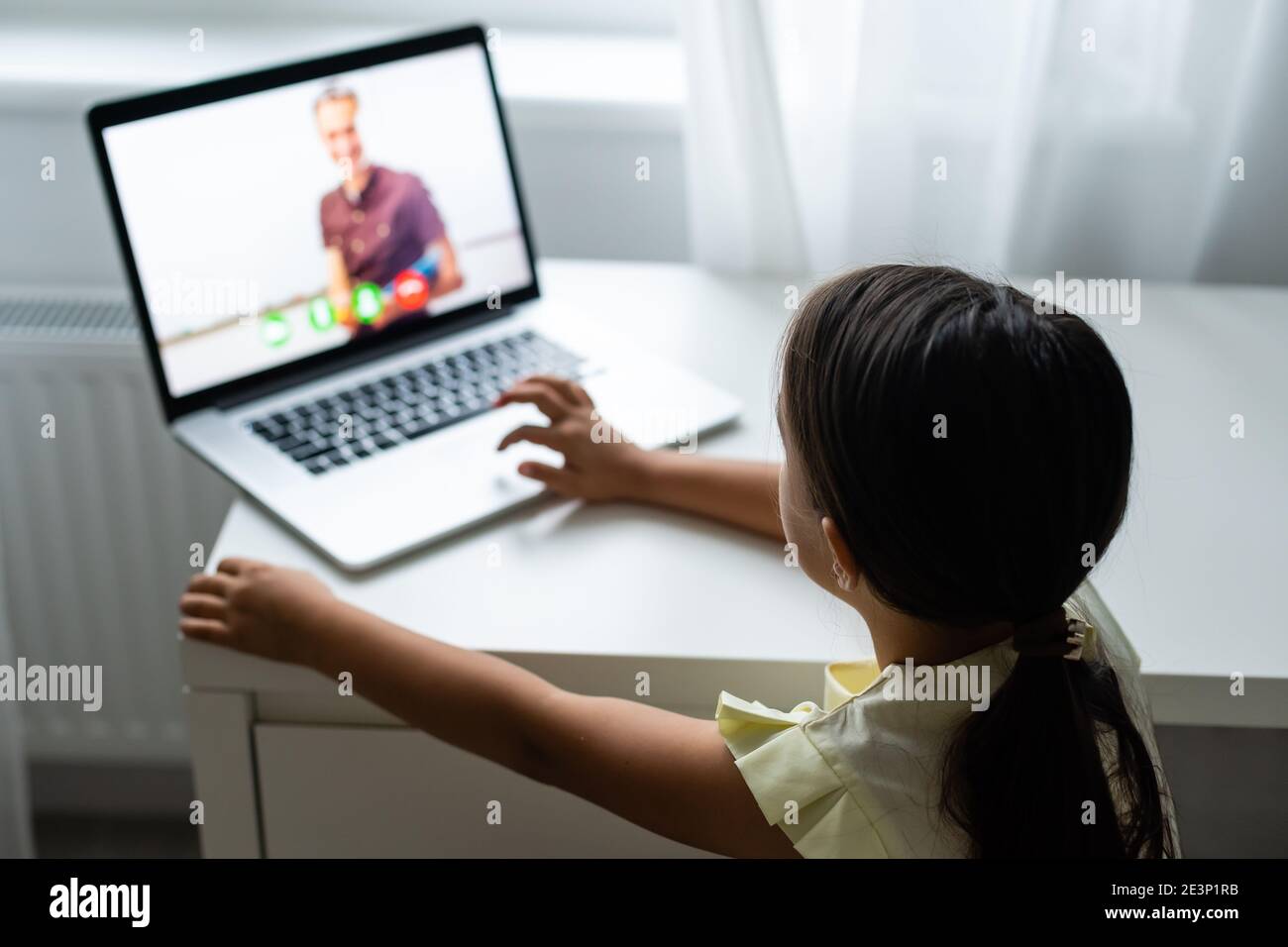 Litttle girl looking at laptop screen with expression of surprised and ...