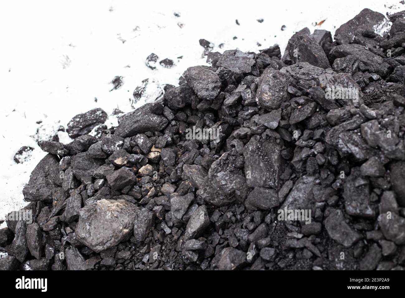 Coarse coal in the snow in winter. Maintaining high temperatures in ...
