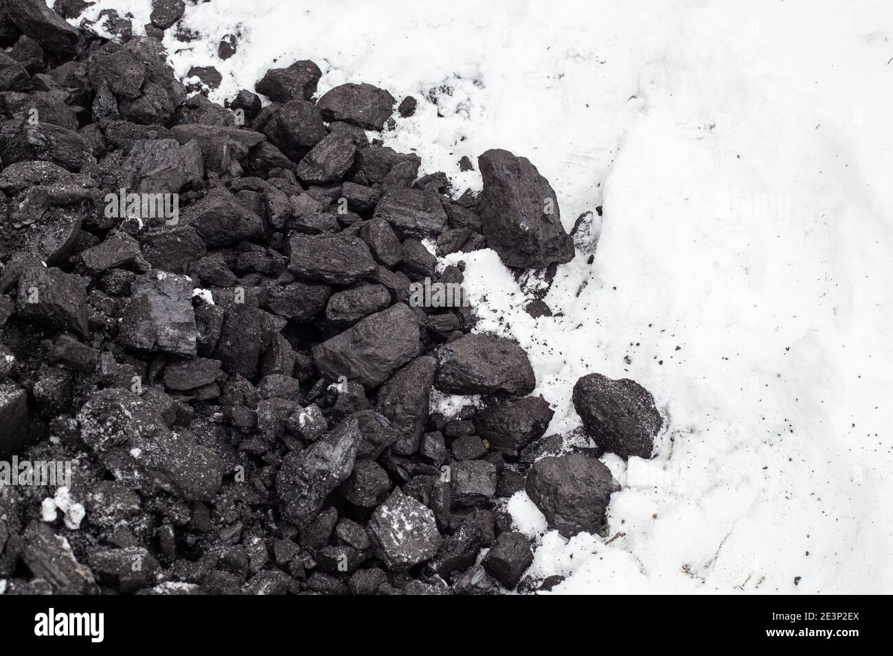 Coarse coal in the snow in winter. Maintaining high temperatures in ...