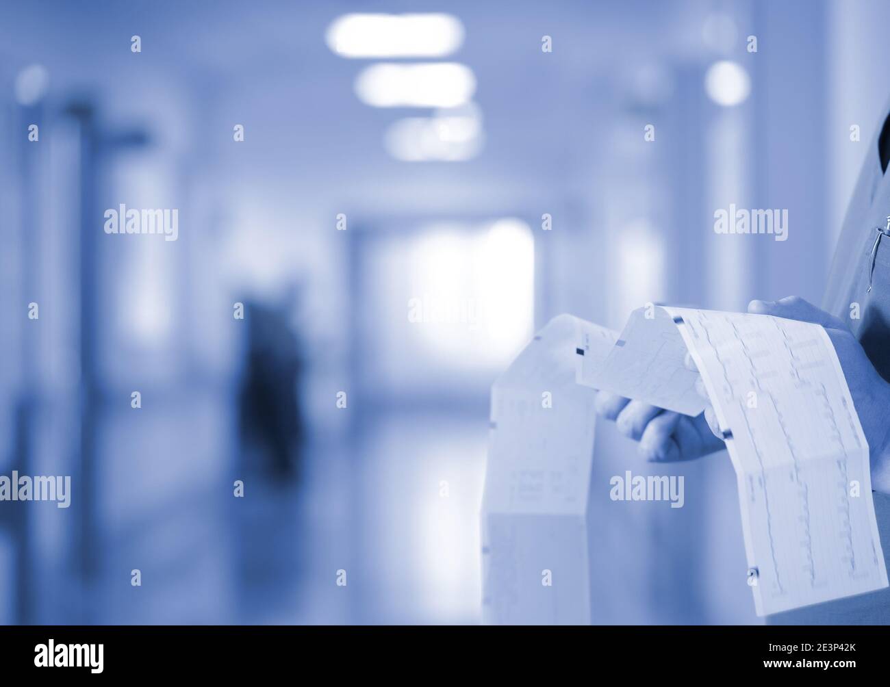 Male doctor examines the patient's ECG trace in the hospital corridor ...