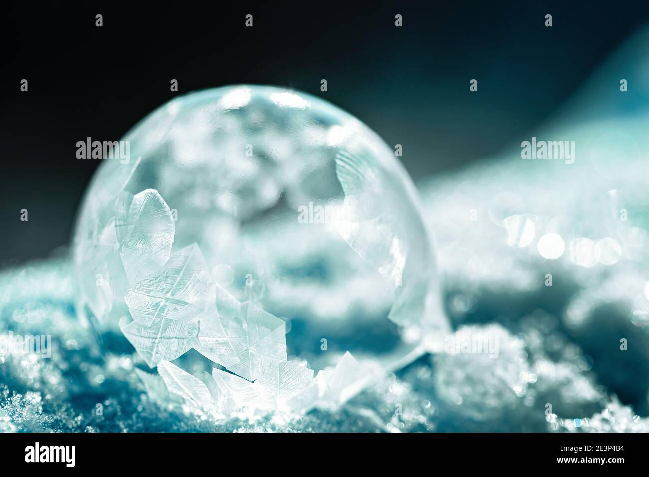frozen bubble with bokeh background. Beautiful frosty patterns on frozen soap bubble. winter ...