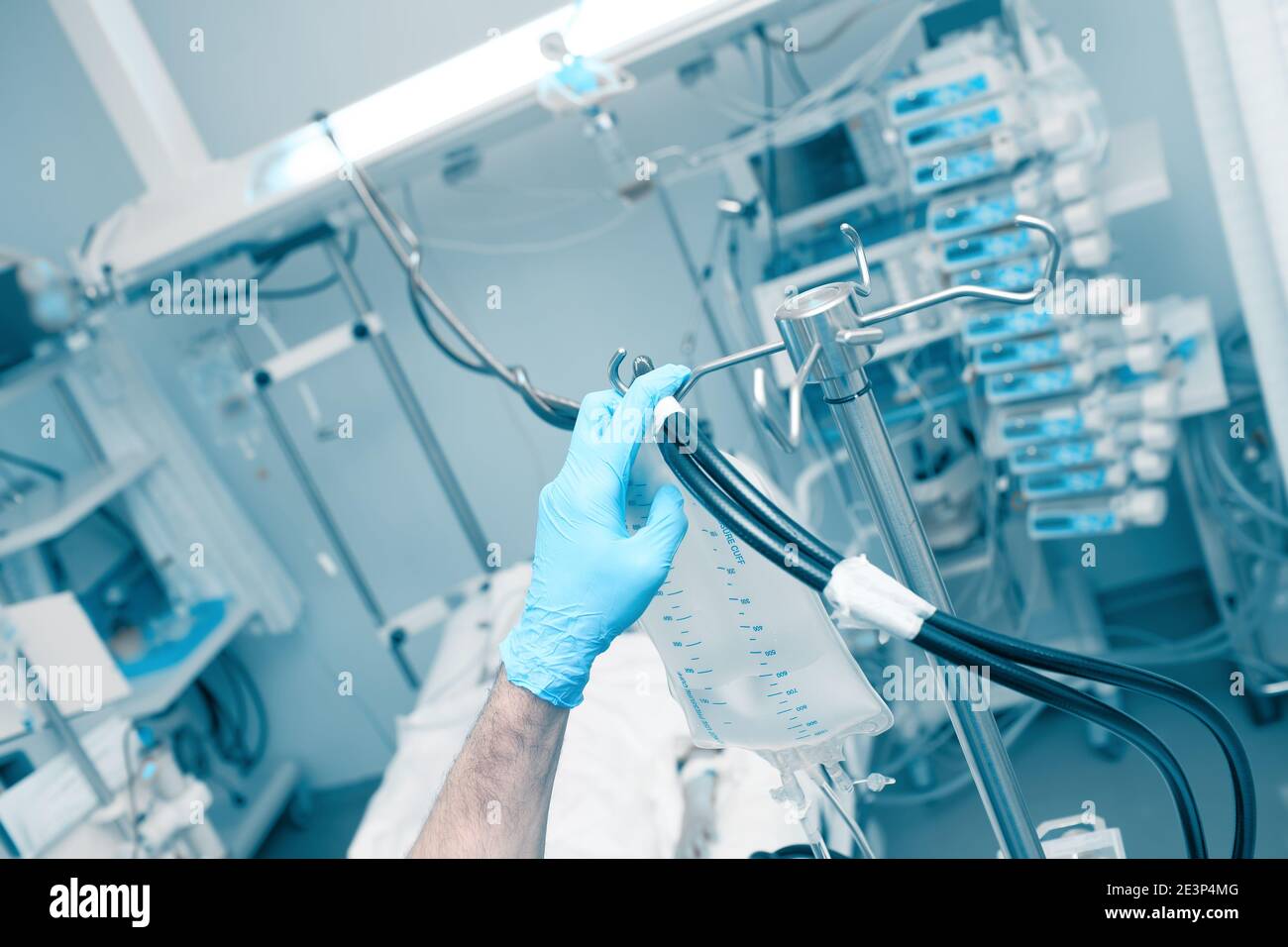 Male doctor sets up the medical equipment next to the patient bed in ...
