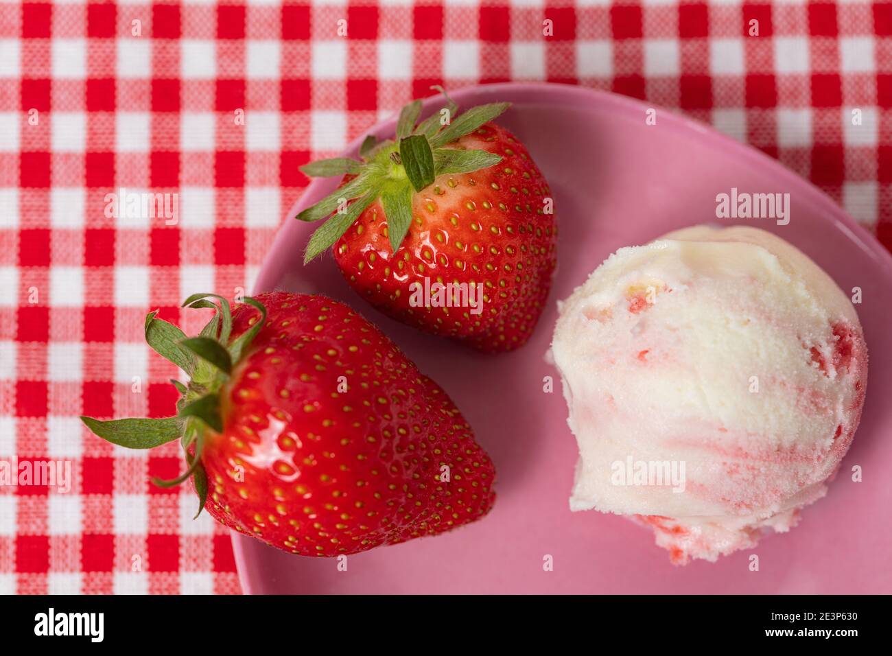 scoop of homemade strawberry ice cream with strawberries and variegato ...