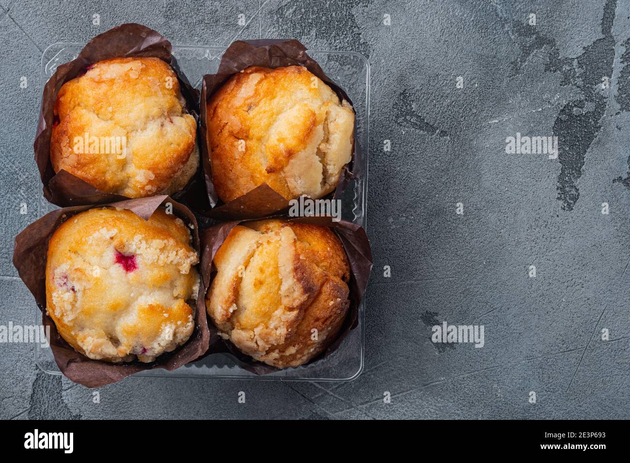 Muffins in plastic container, on gray background, top view flat lay ...