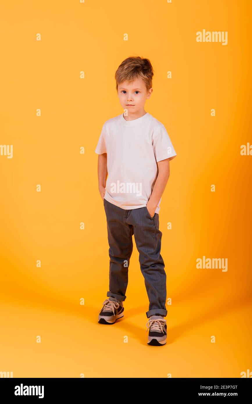 Portrait of happy little boy over yellow background in studio Stock ...